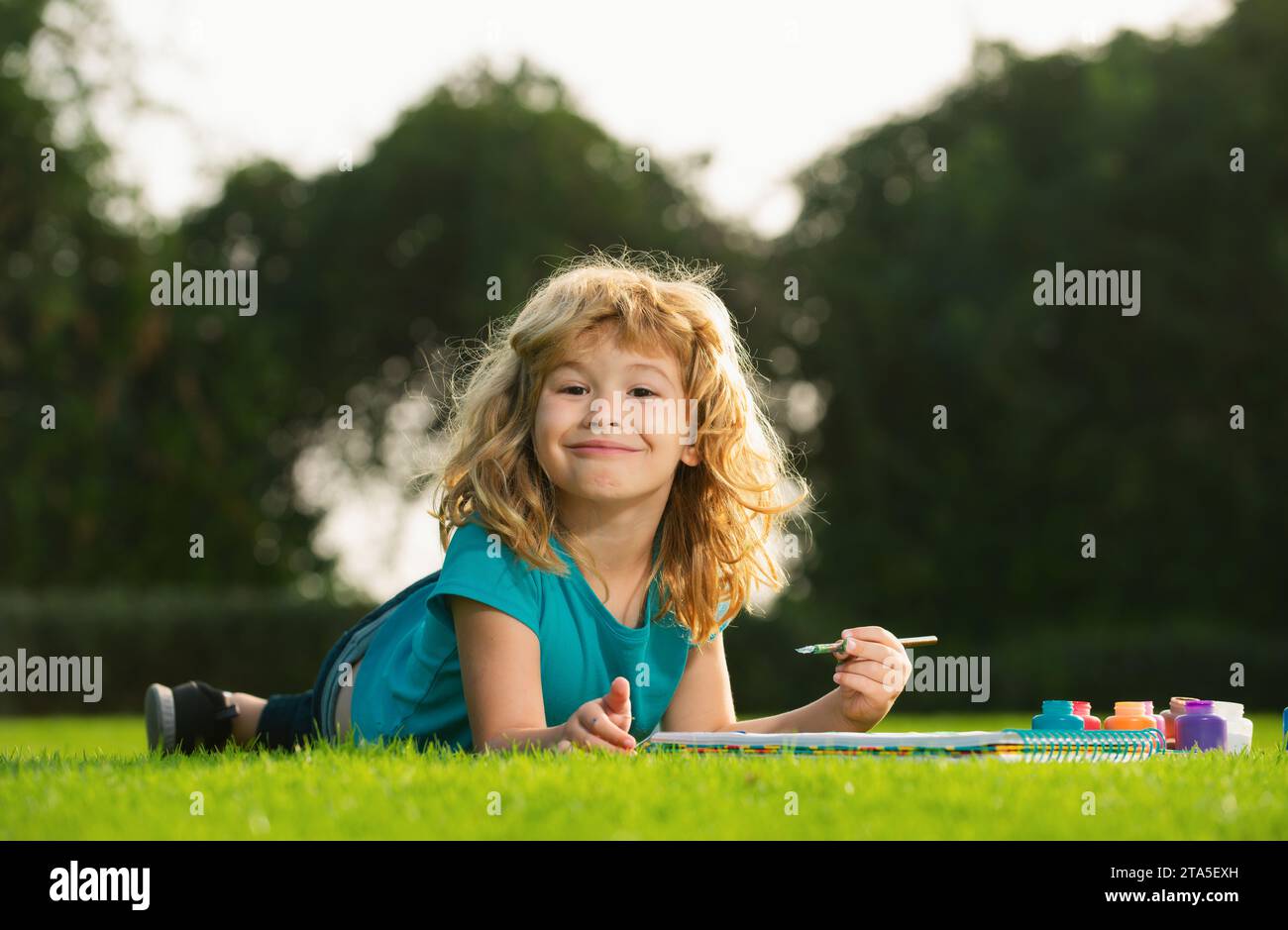 Children draw paint pictures outside, childrens creativity. Kid draws ...