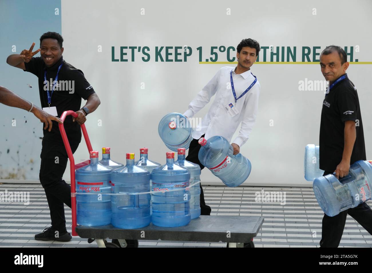 Men carry water containers ahead of the COP28 U.N. Climate Summit ...