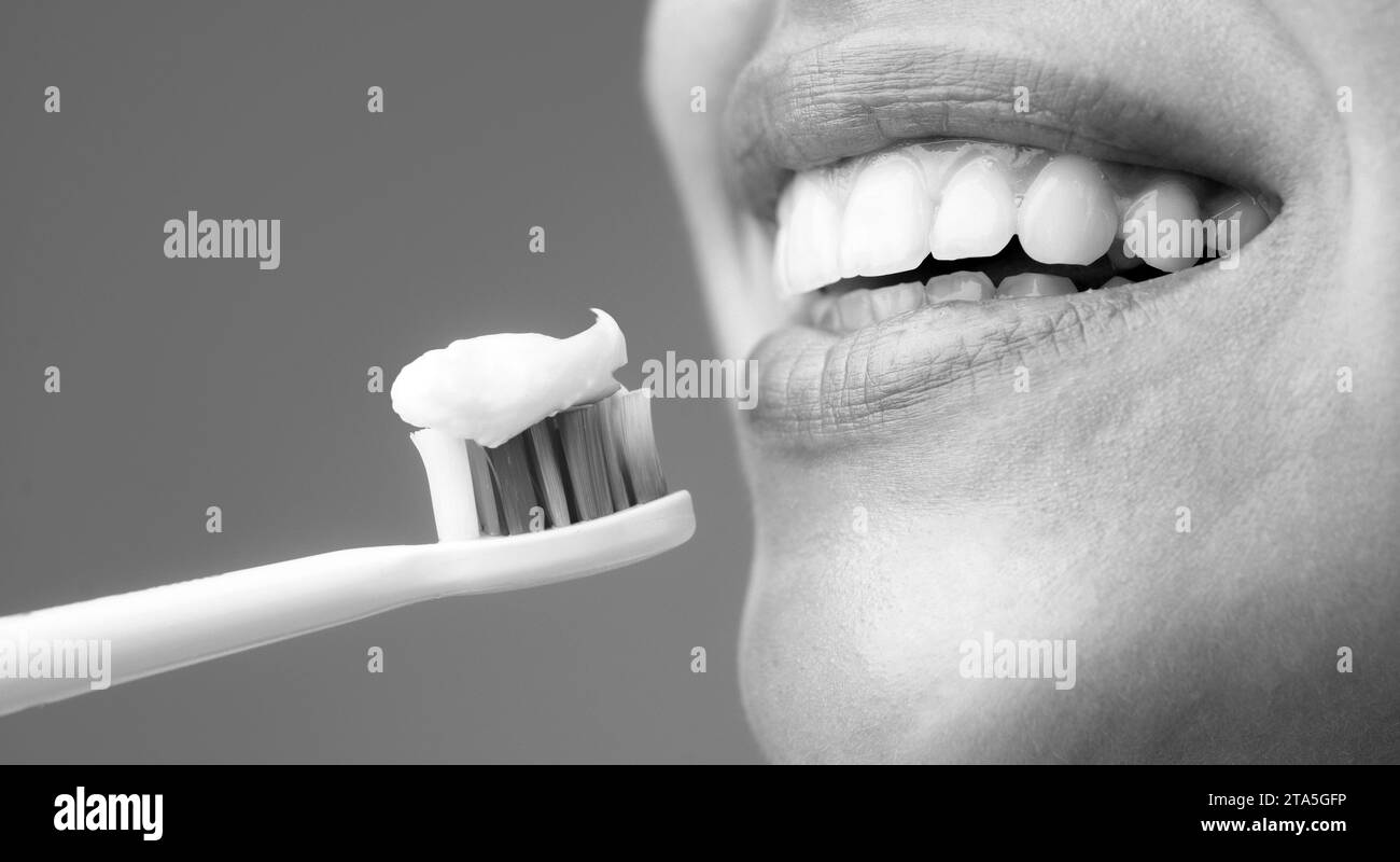 Toothbrush with toothpaste. Young cheerful woman brushing teeth with ...