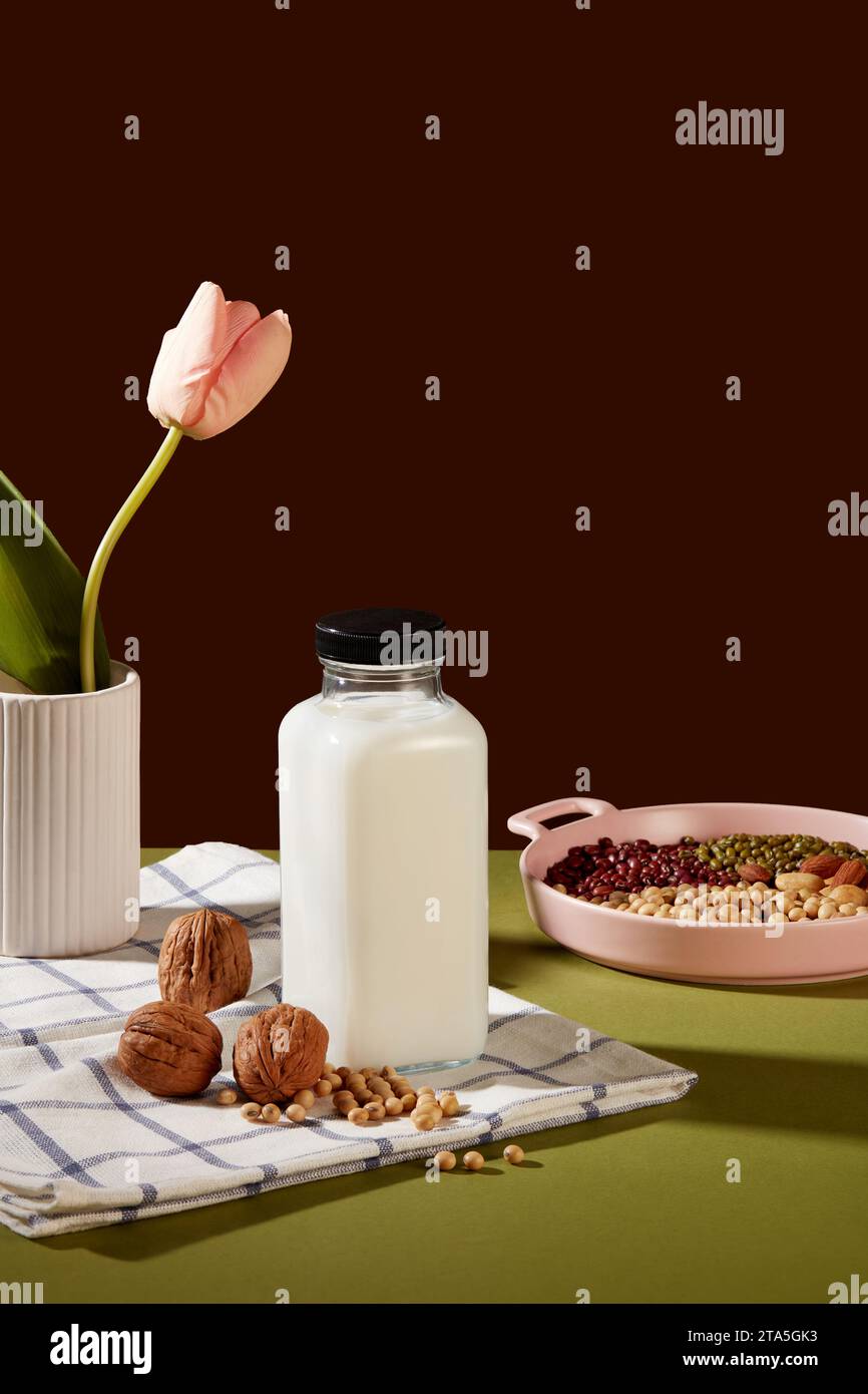 Raw mixed nuts are displayed inside a dish in pink color. A milk bottle ...