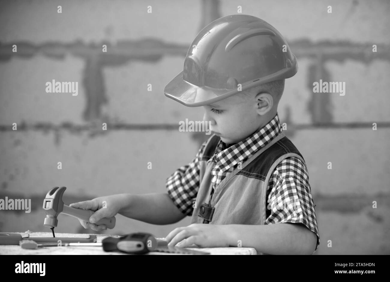 Child in helmet is construction worker. Foreman kid work in the hard ...