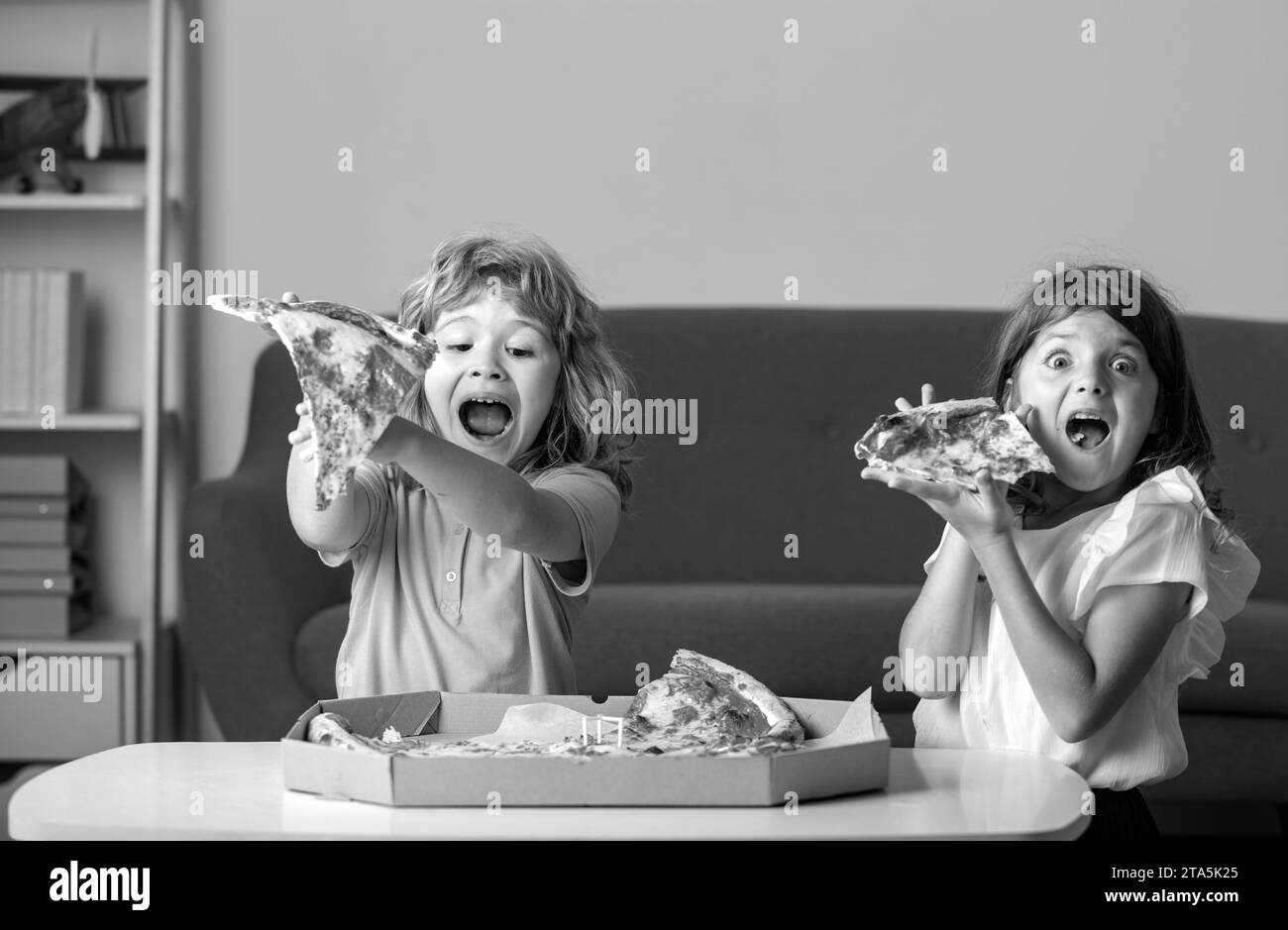 Children eating pizza. Excited kids eating pizza. Two young children ...