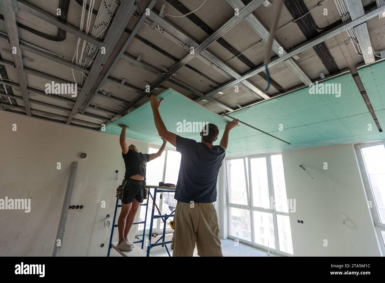 Construction worker ceiling work installation Stock Photo - Alamy