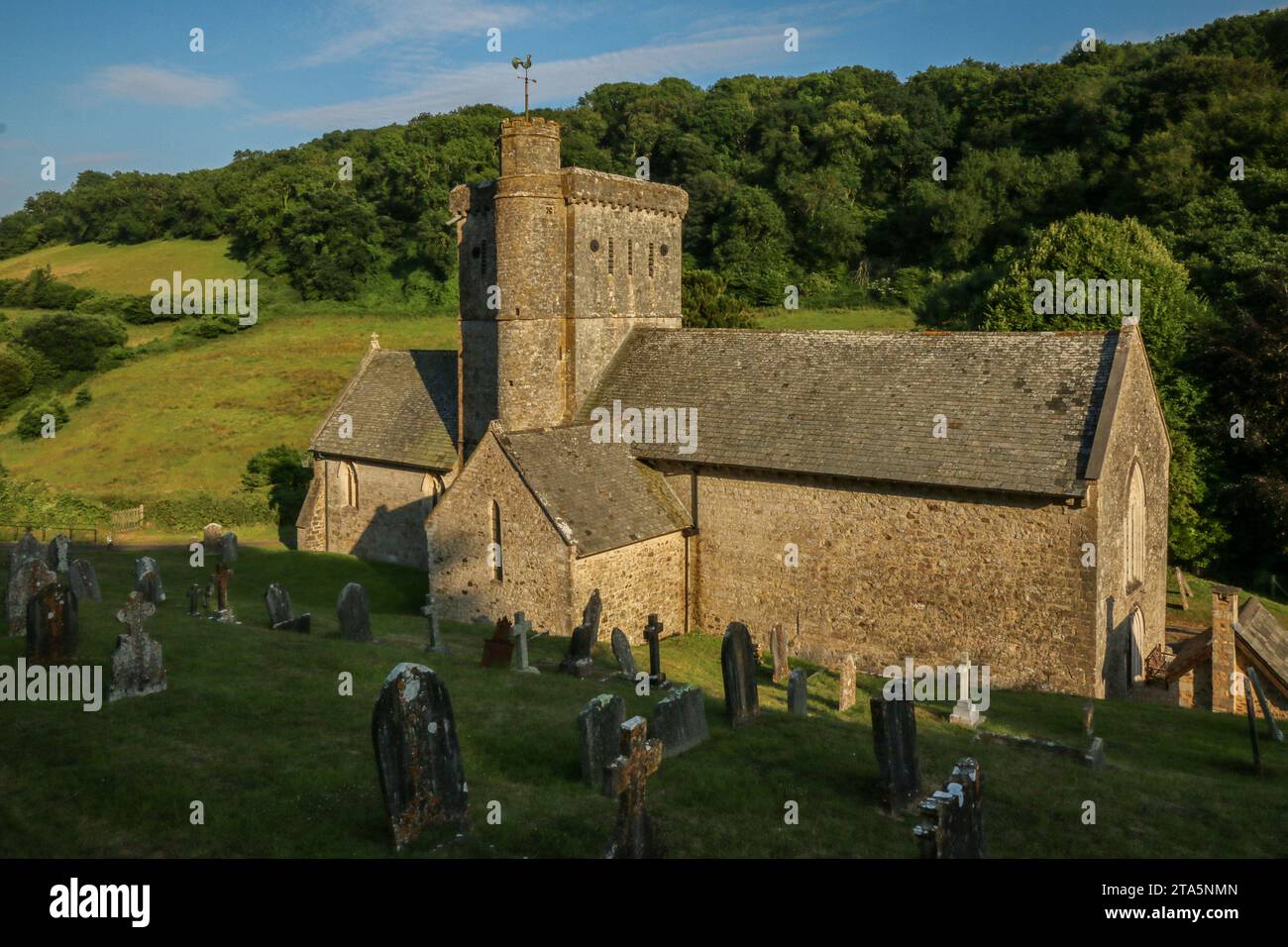 Old stone church and old graveyard in the clearing, Devon, England ...