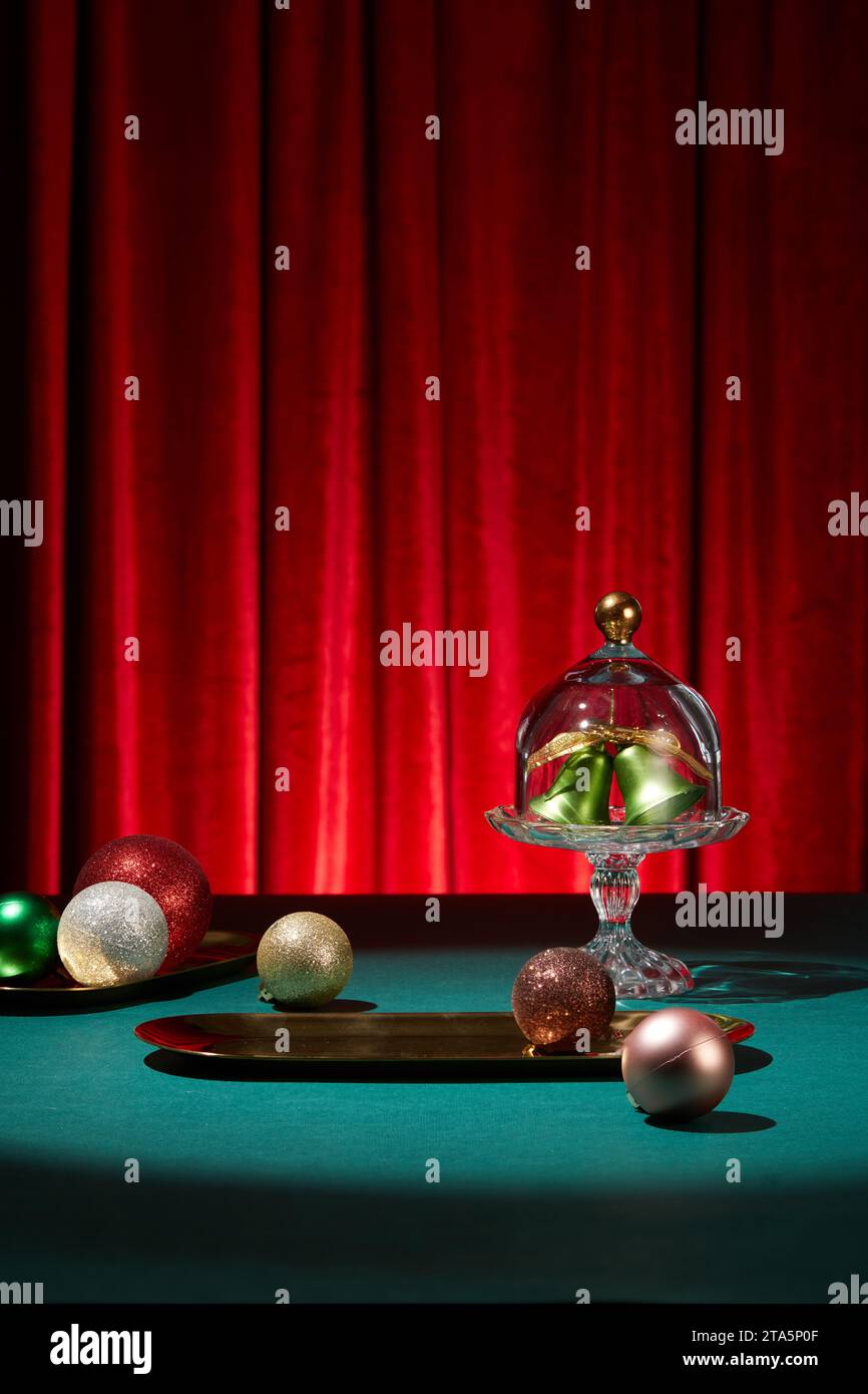 Red background with colorful decoration, small golden bells on glass ...