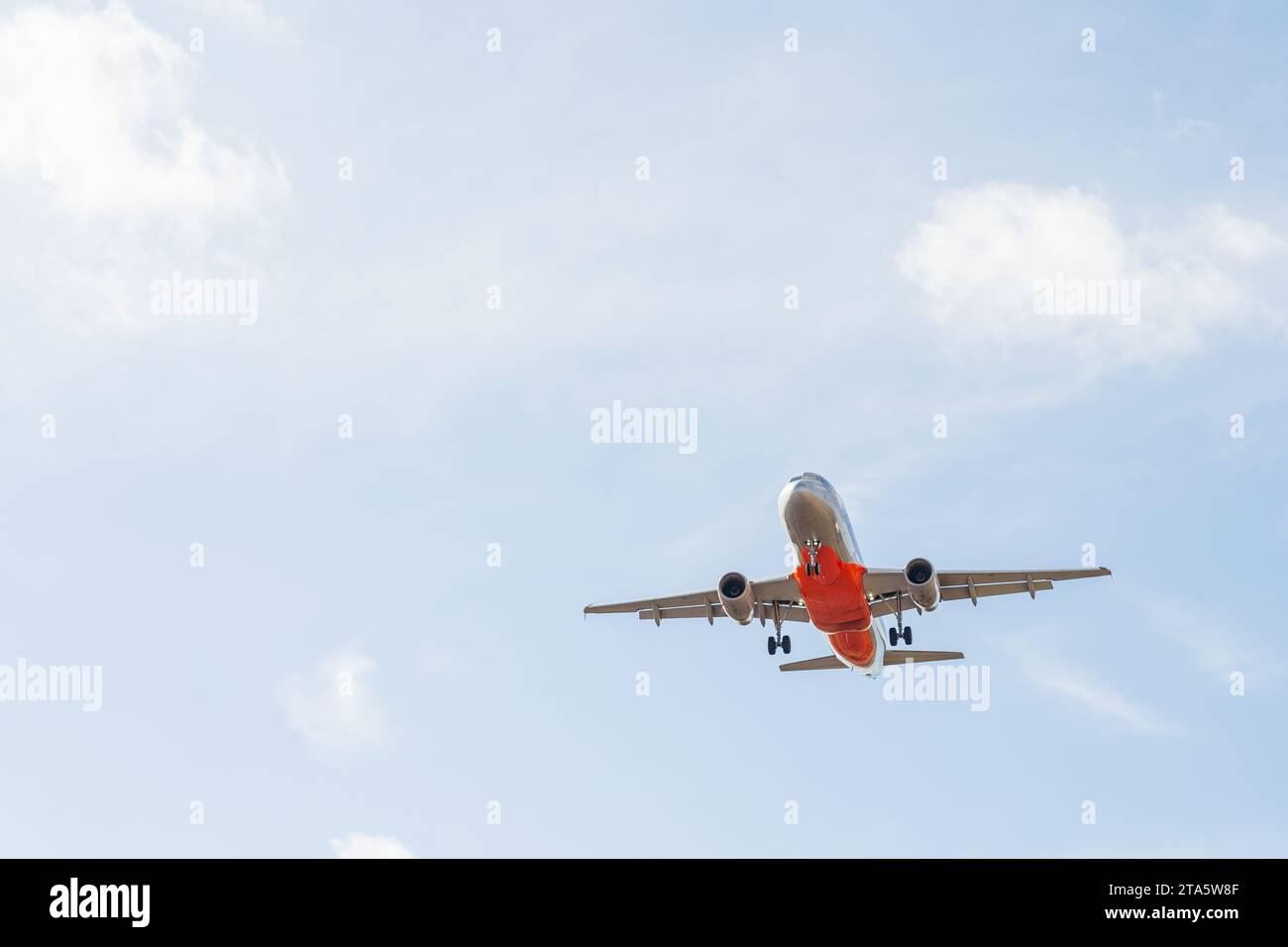 Looking up at a low flying passenger jet coming in to land at ...