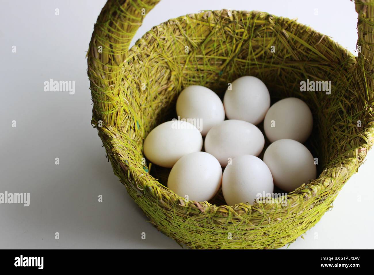 Eight White Eggs In A Basket Made From Wicker And Green Grass Stock ...