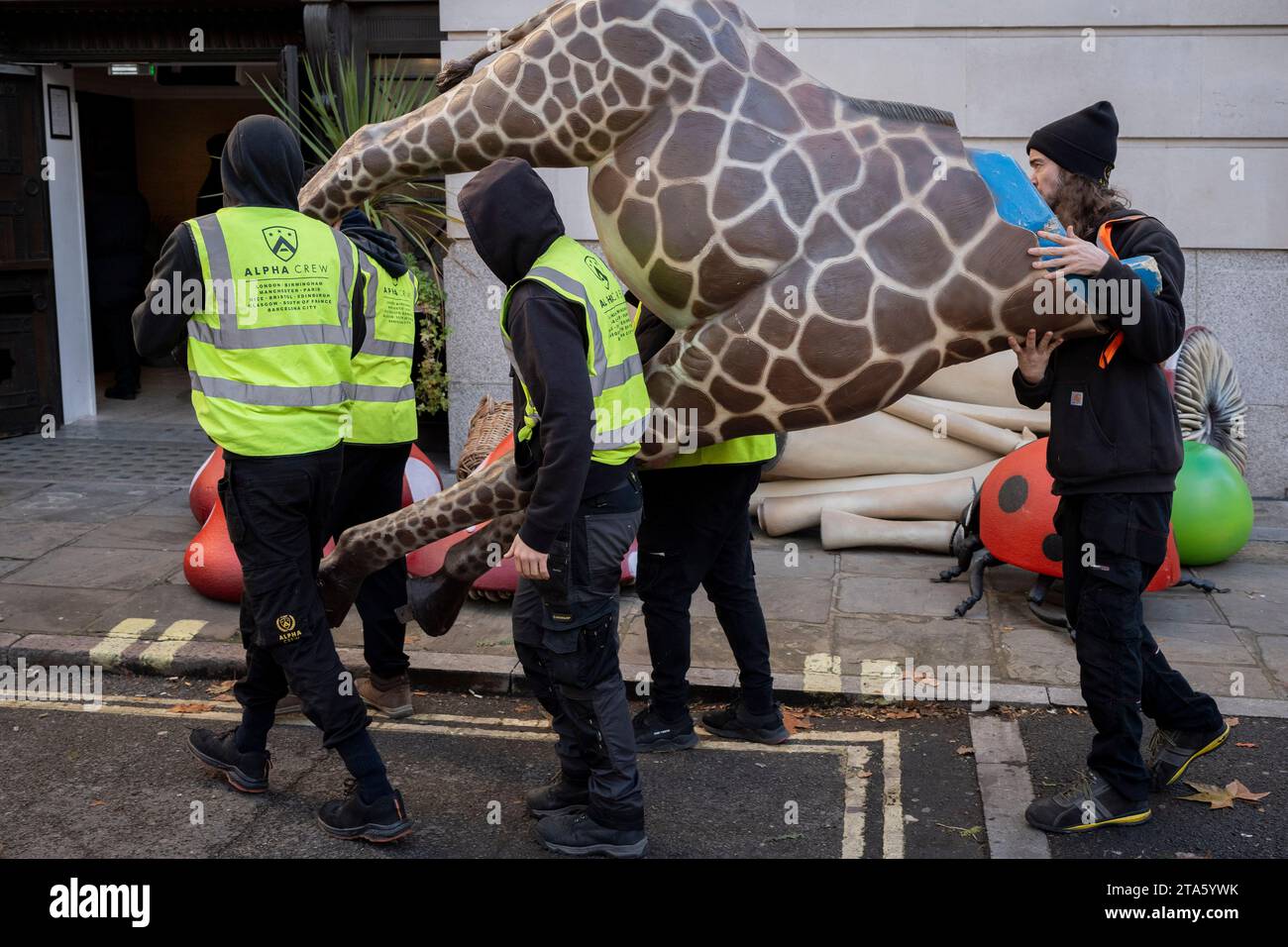 A work crew organises and carries fibreglass props including a headless ...