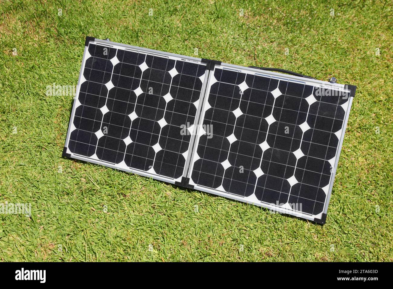 Portable solar panels on green grass. Solar power has become a mainstay ...
