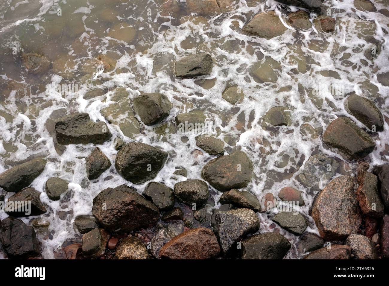 Stony seashore with foam in tidal bore sea waves top view Stock Photo ...