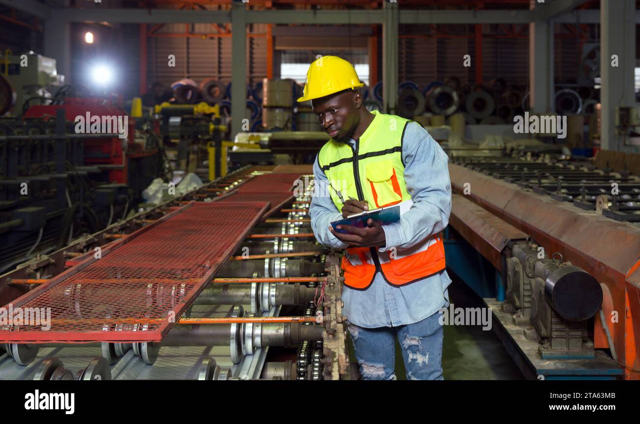 A factory worker is standing on a production line conveyor belt ...