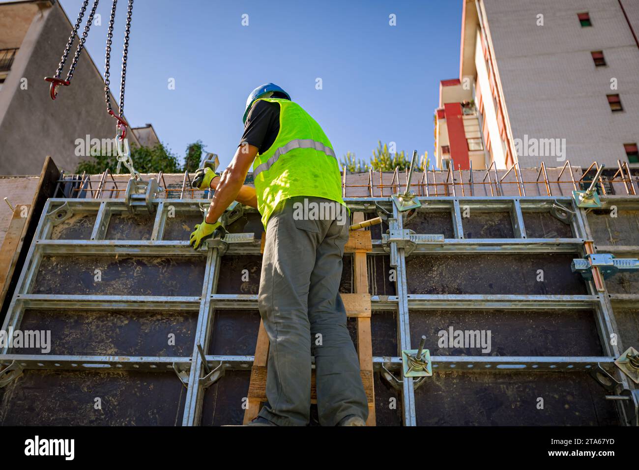 View from behind on construction worker with safety vest and yellow ...