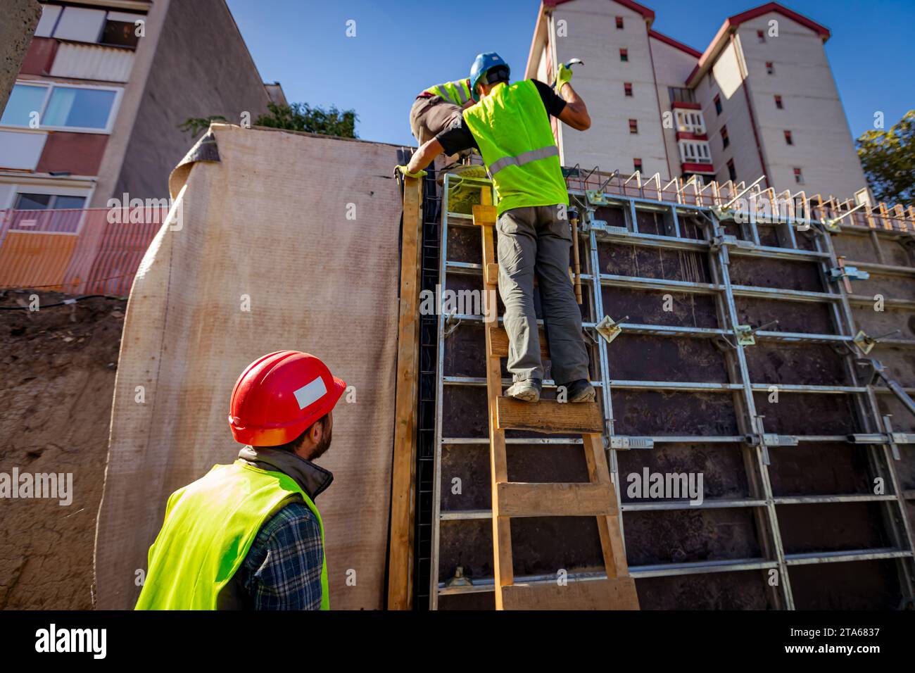 View from behind on construction worker with safety vest and yellow ...
