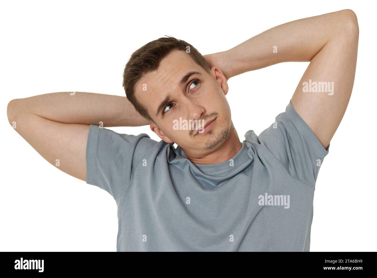 young man holding hands behind head on white background Stock Photo - Alamy