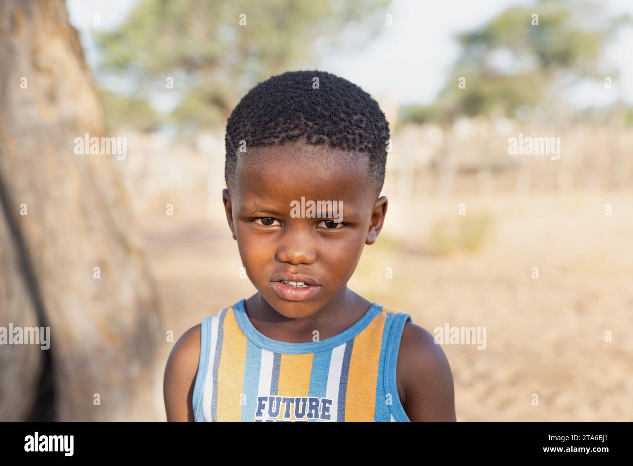 village african child standing in the yard late afternoon at sunset ...