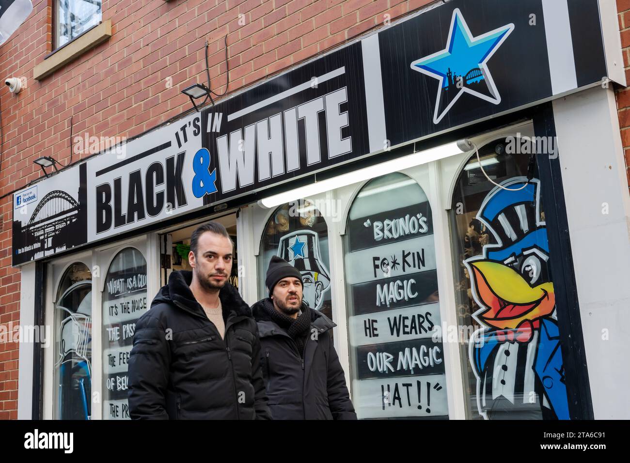 Two people walk past the It's In Black and White shop, which sells ...