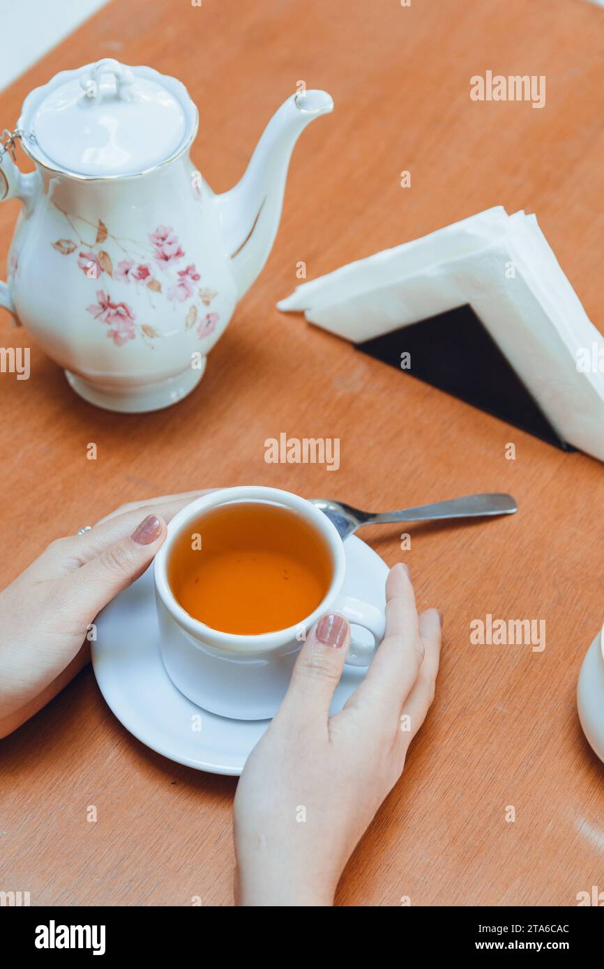 vertical image of young unrecognizable caucasian female hands on table ...