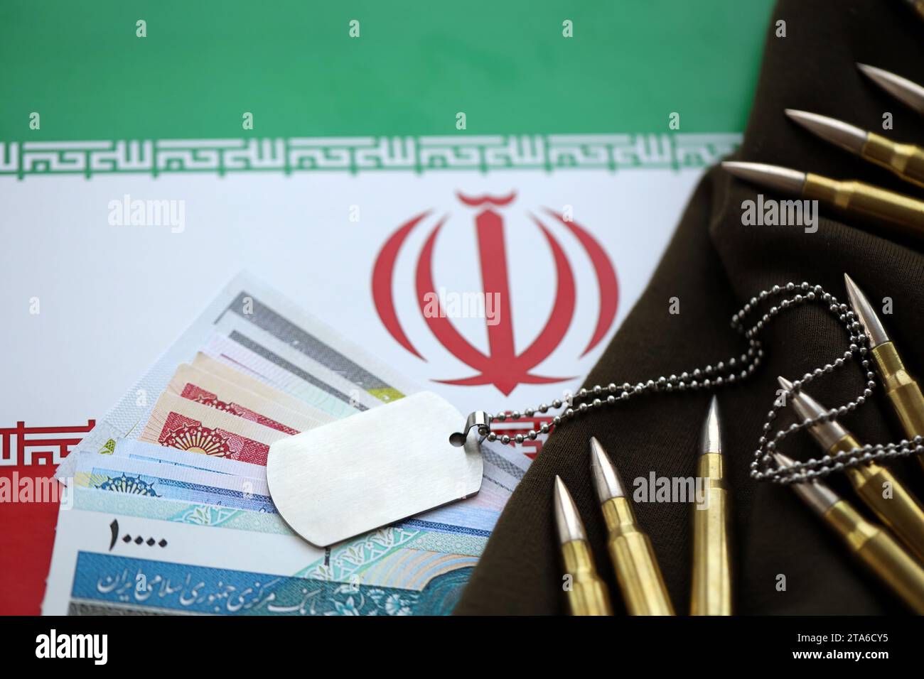 Many bullets and iranian rials money bills on flag of Islamic Republic ...