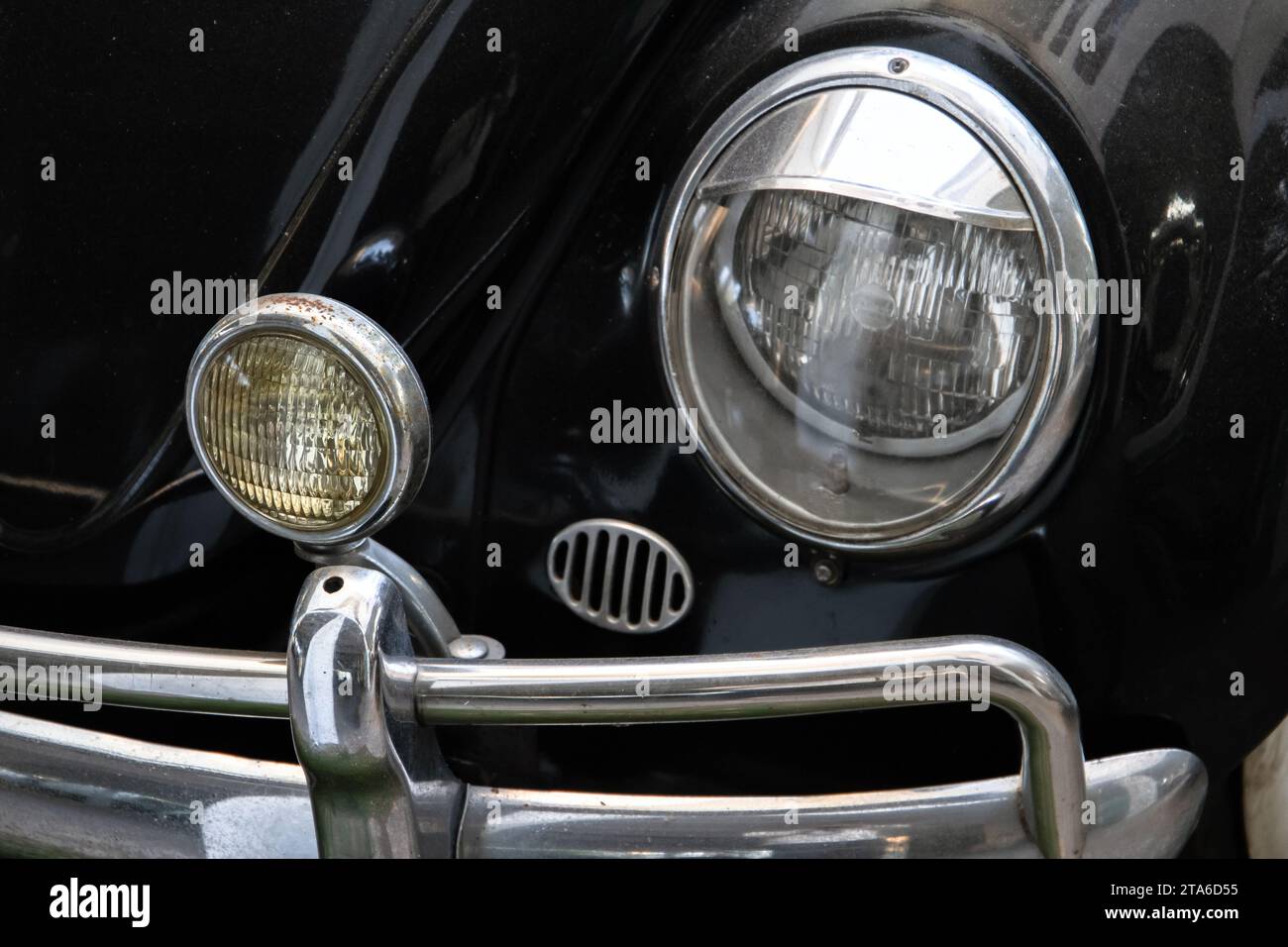 Round headlights of a vintage black car. Close-up photo with selective ...