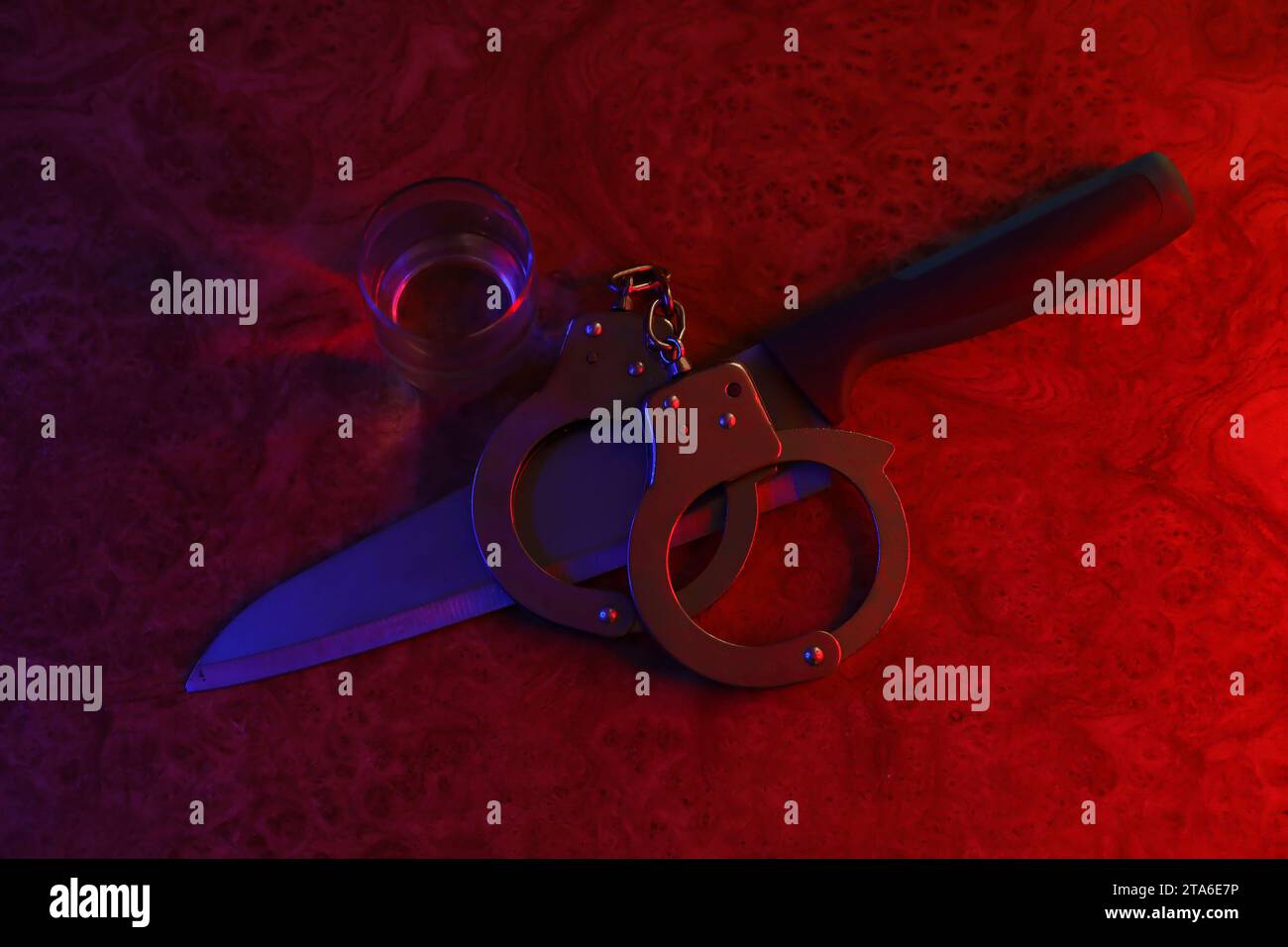 Glass with vodka alcohol drink, knife and handcuffs. Concept of ...