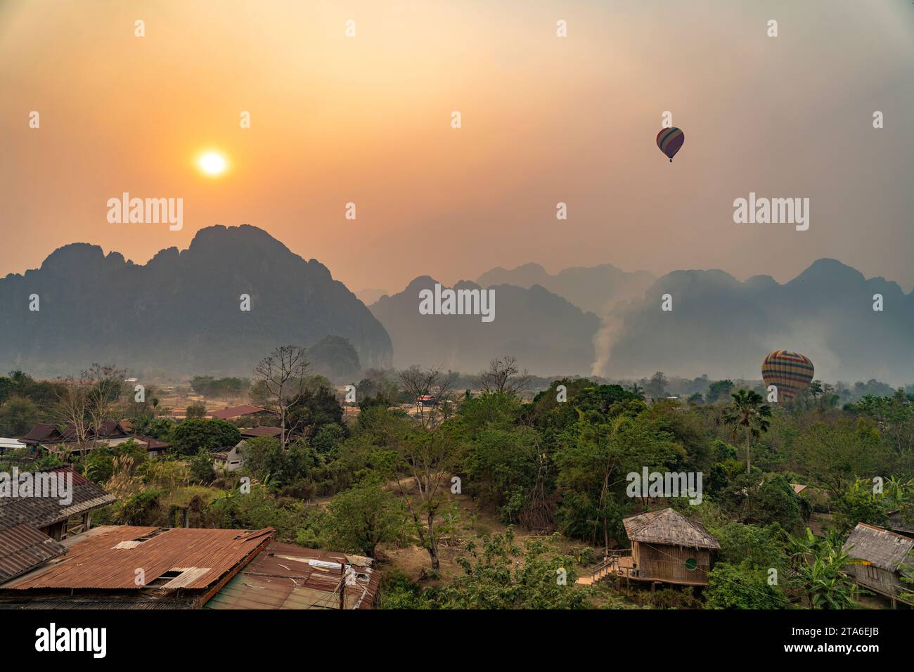 Heissluftballon bei Sonnenaufgang in der Landschaft von Vang Vieng ...