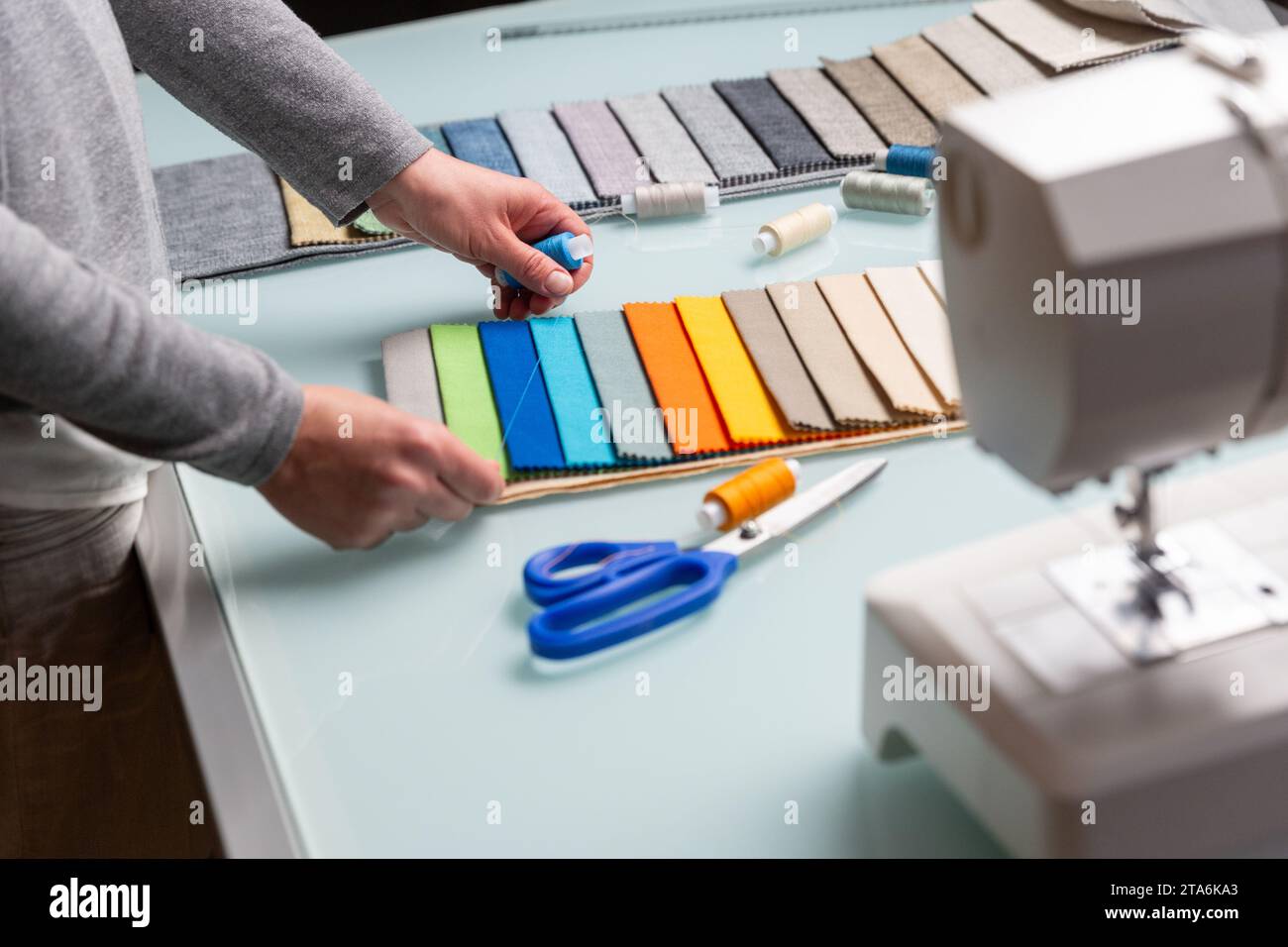 Tailor choosing right color of a blue thread using fabric samples on ...