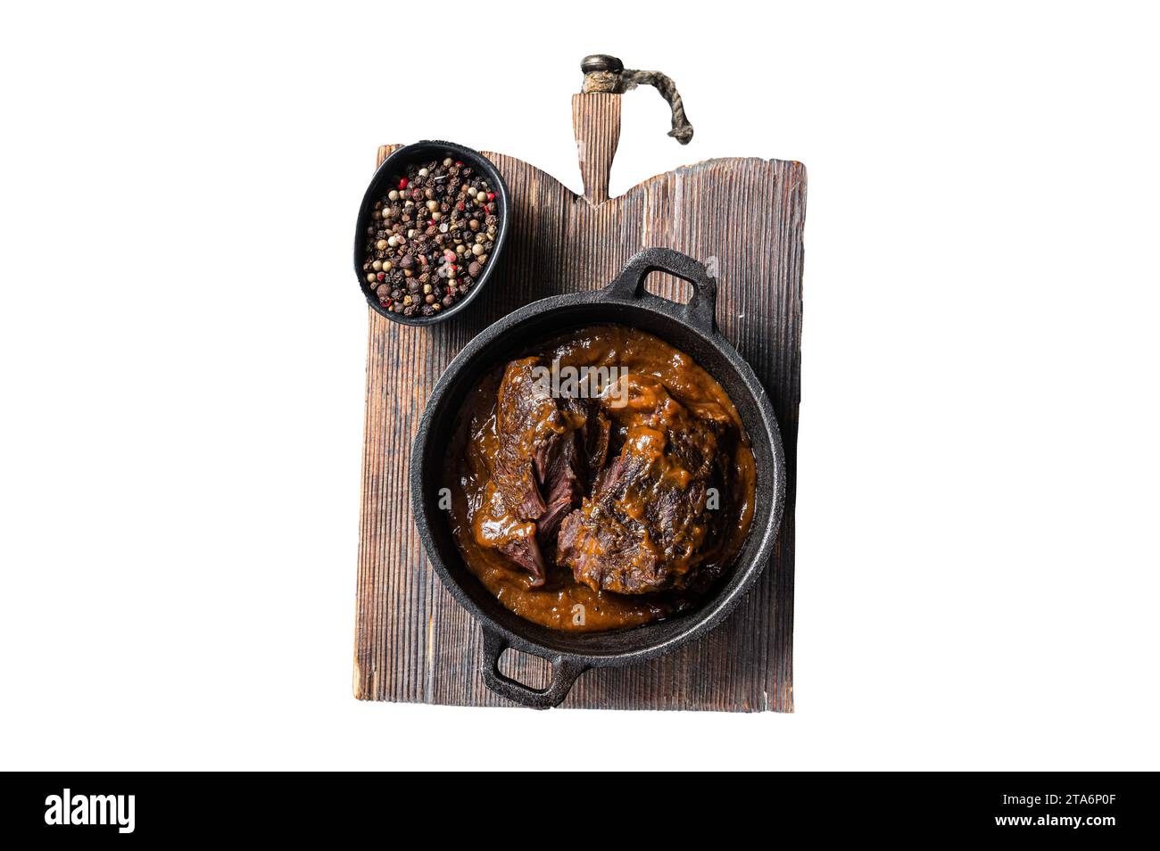 Stewed beef cheeks with brown red wine sauce in skillet. Isolated ...