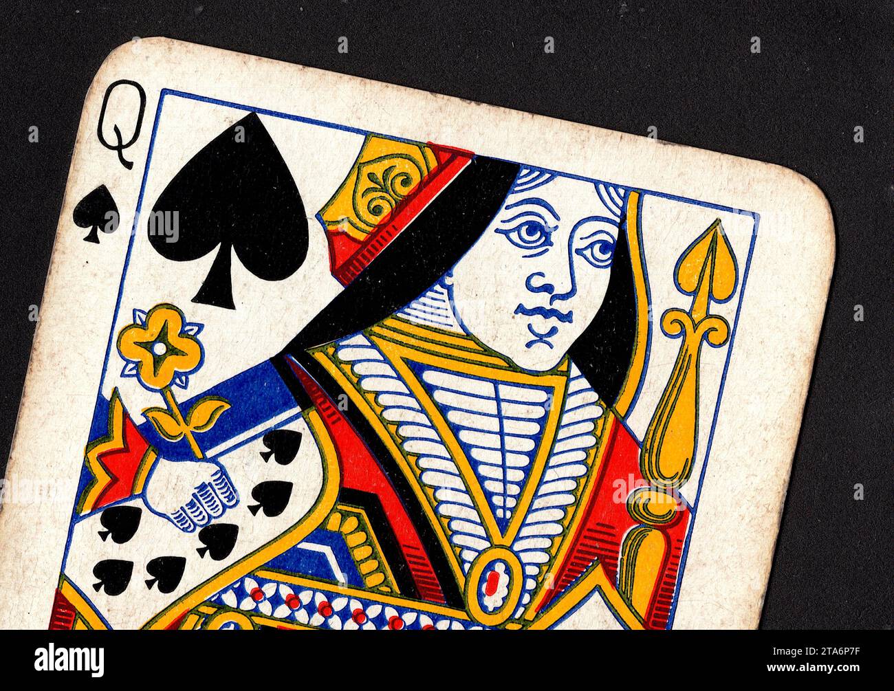 Close up of a vintage queen of spades playing card isolated on a black ...