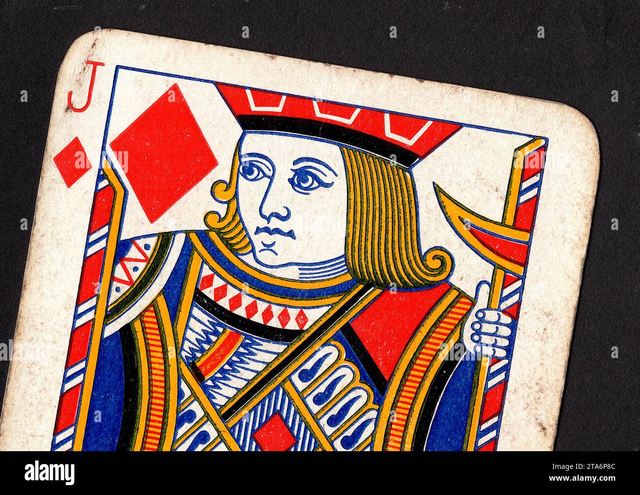 Close up of a vintage jack of diamonds playing card isolated on a black ...