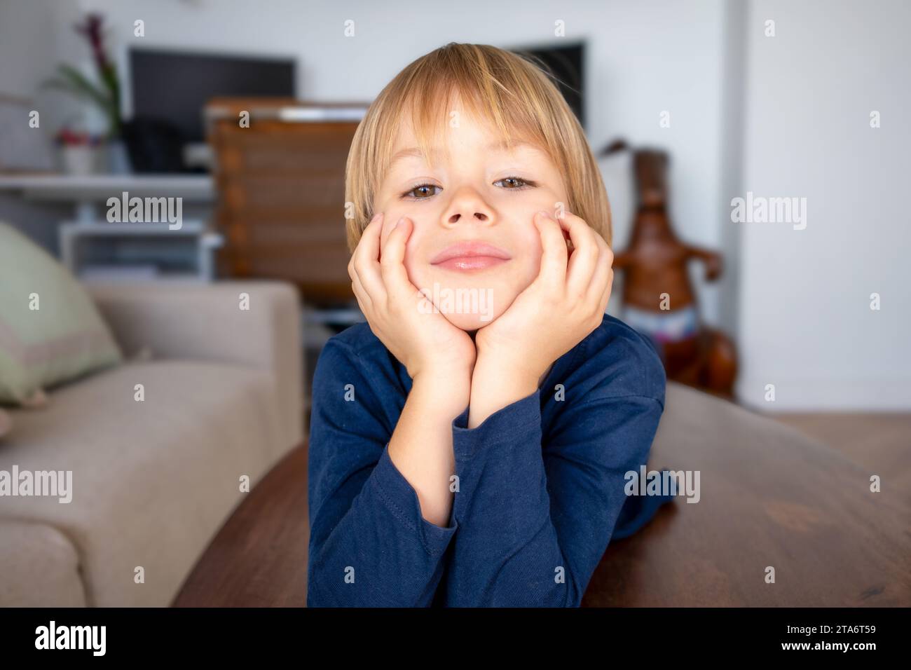 The boy lies on the table and dreams. The emotions of a child. Portrait ...