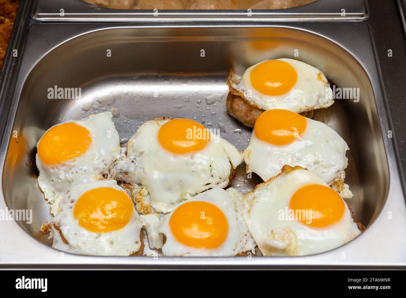 Beef Steaks with fried egg in stainless steel tray. Fried eggs with ...