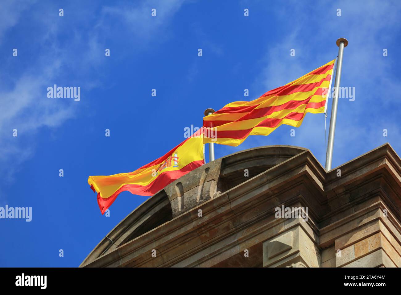 Flag of Spain and flag of Catalonia side by side in the wind atop the ...