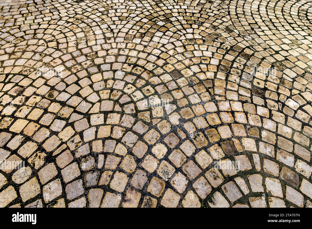 Tufa / limestone setts laid in circular fan pattern in city courtyard ...
