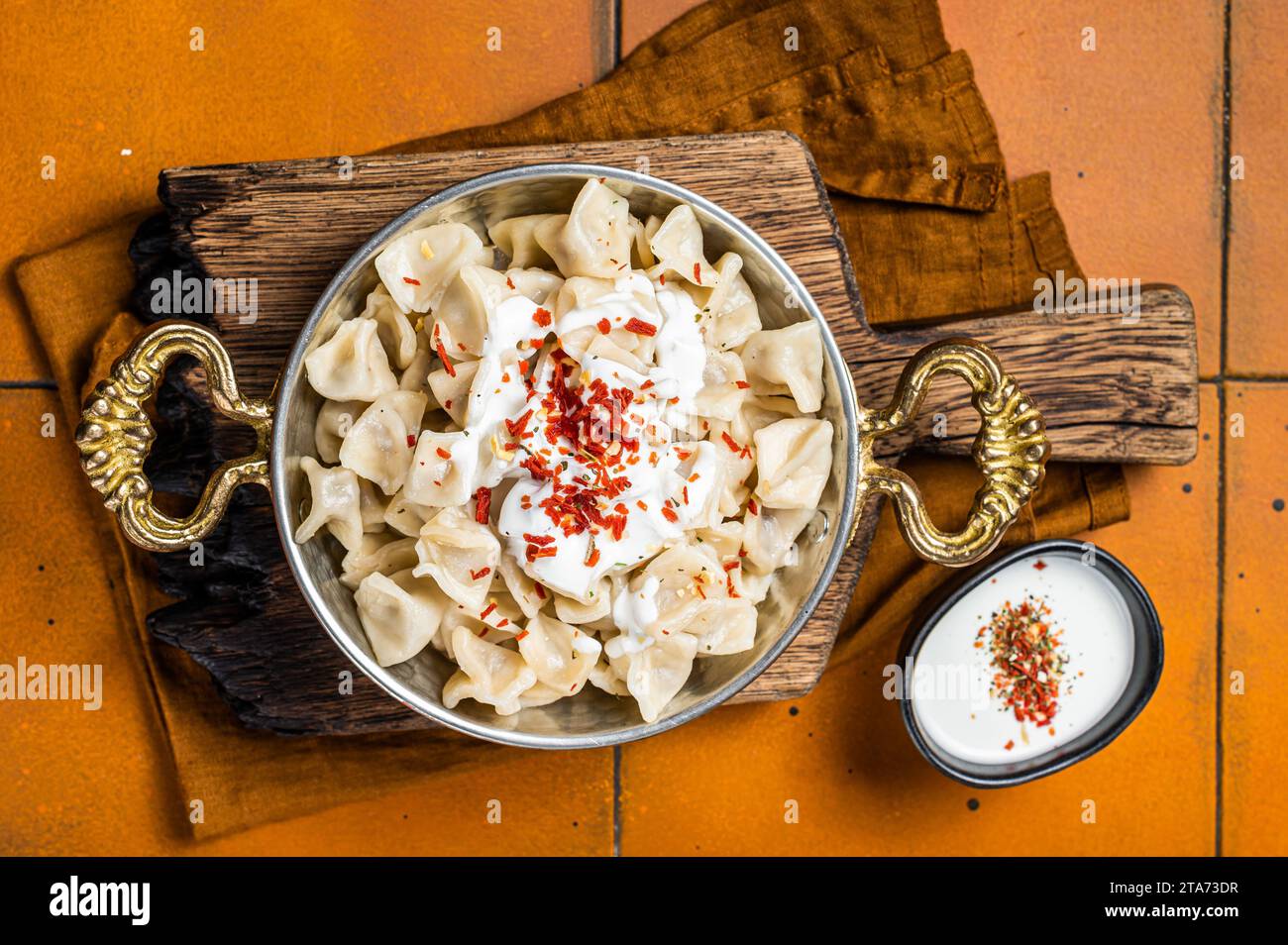 Turkish traditional manti with yoghurt and tomato sauce in a skillet ...