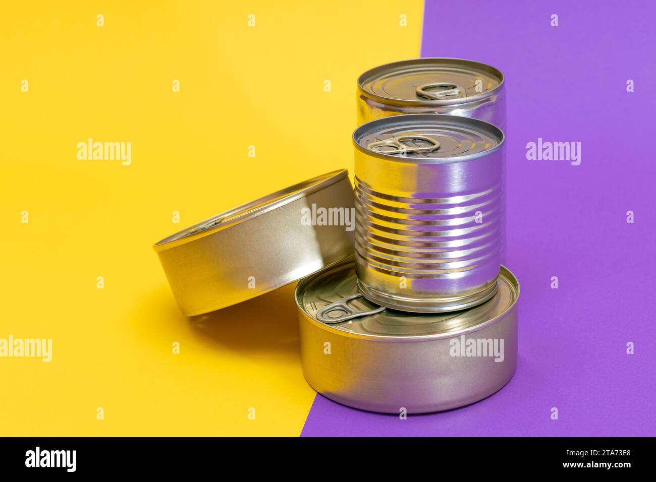 A Group of Stacked Tin Cans with Blank Edges on Split Yellow and Violet ...