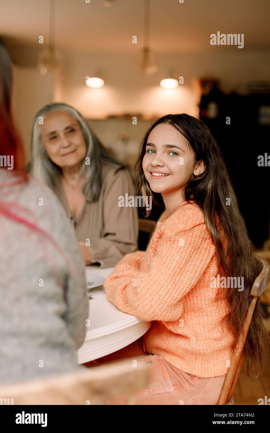 Smiling girl sitting table hi-res stock photography and images - Alamy