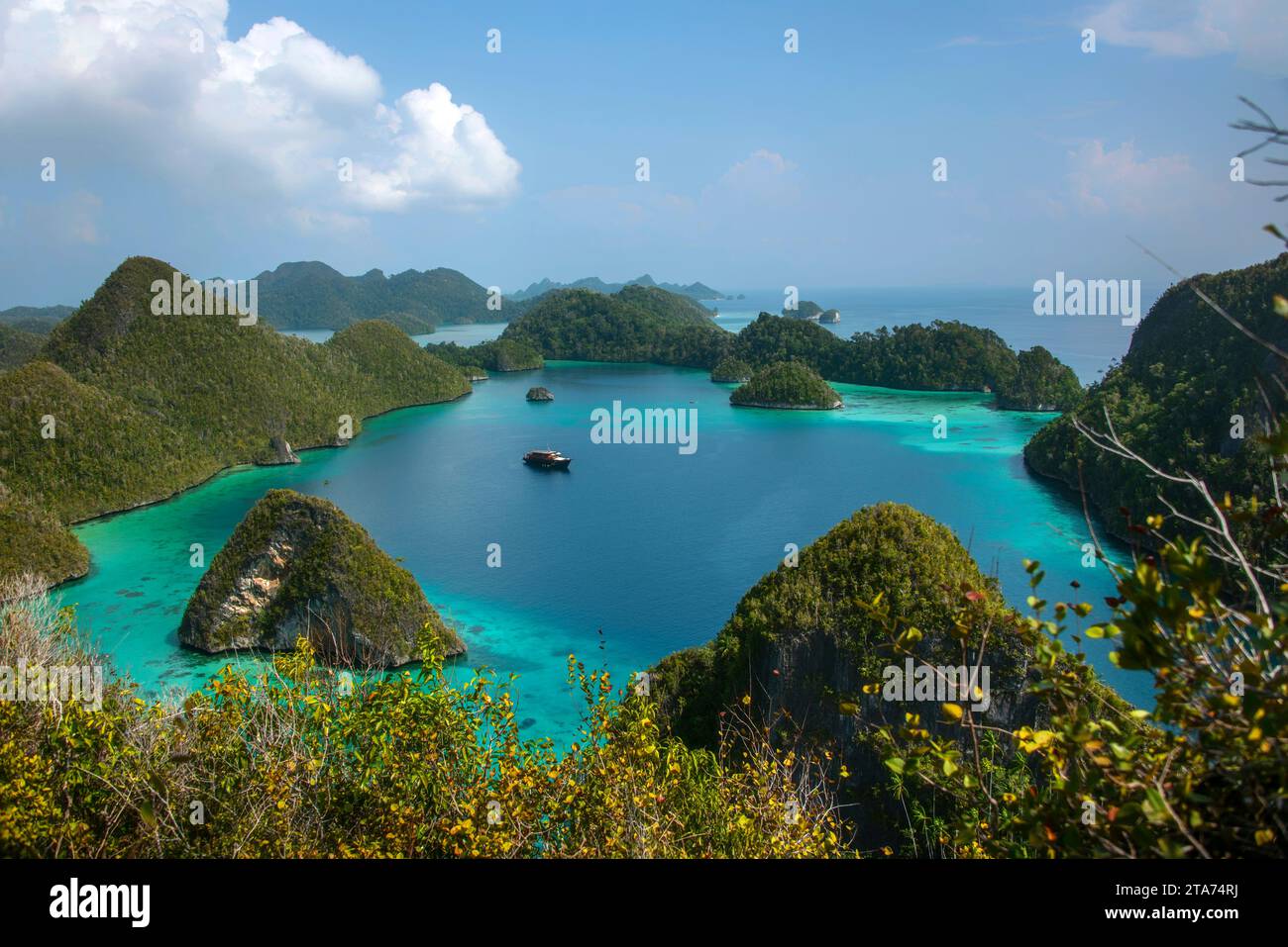 Tourboat anchored in a tropical lagoon, Wayag, Raja Ampat, West Papua ...