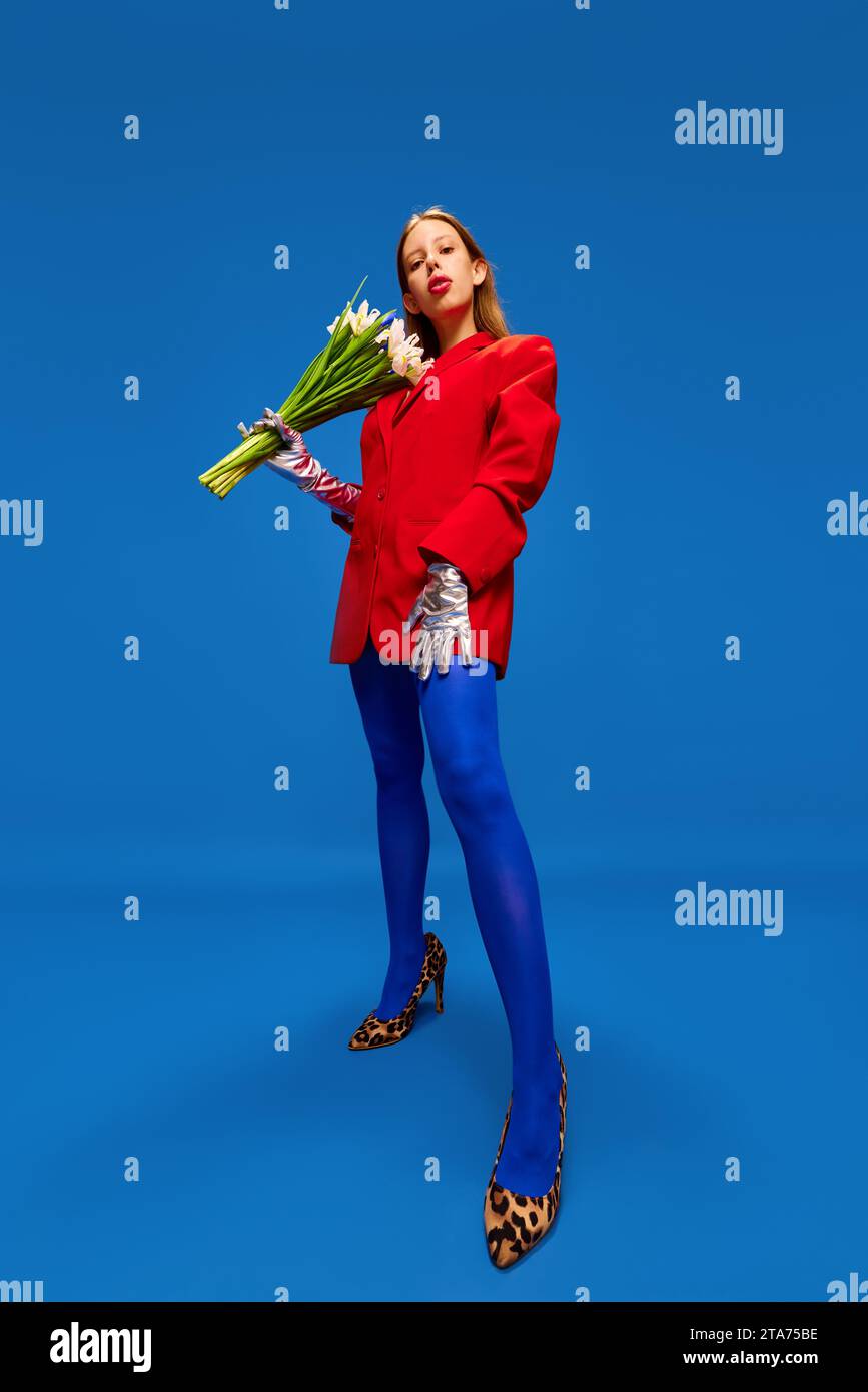 Stylish, weird young woman in extraordinary bright clothes posing ...