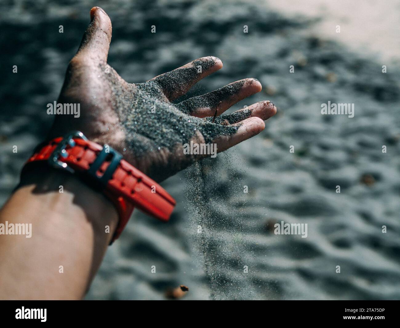 Black sand as background. Hands holding sand in dark background. Black ...