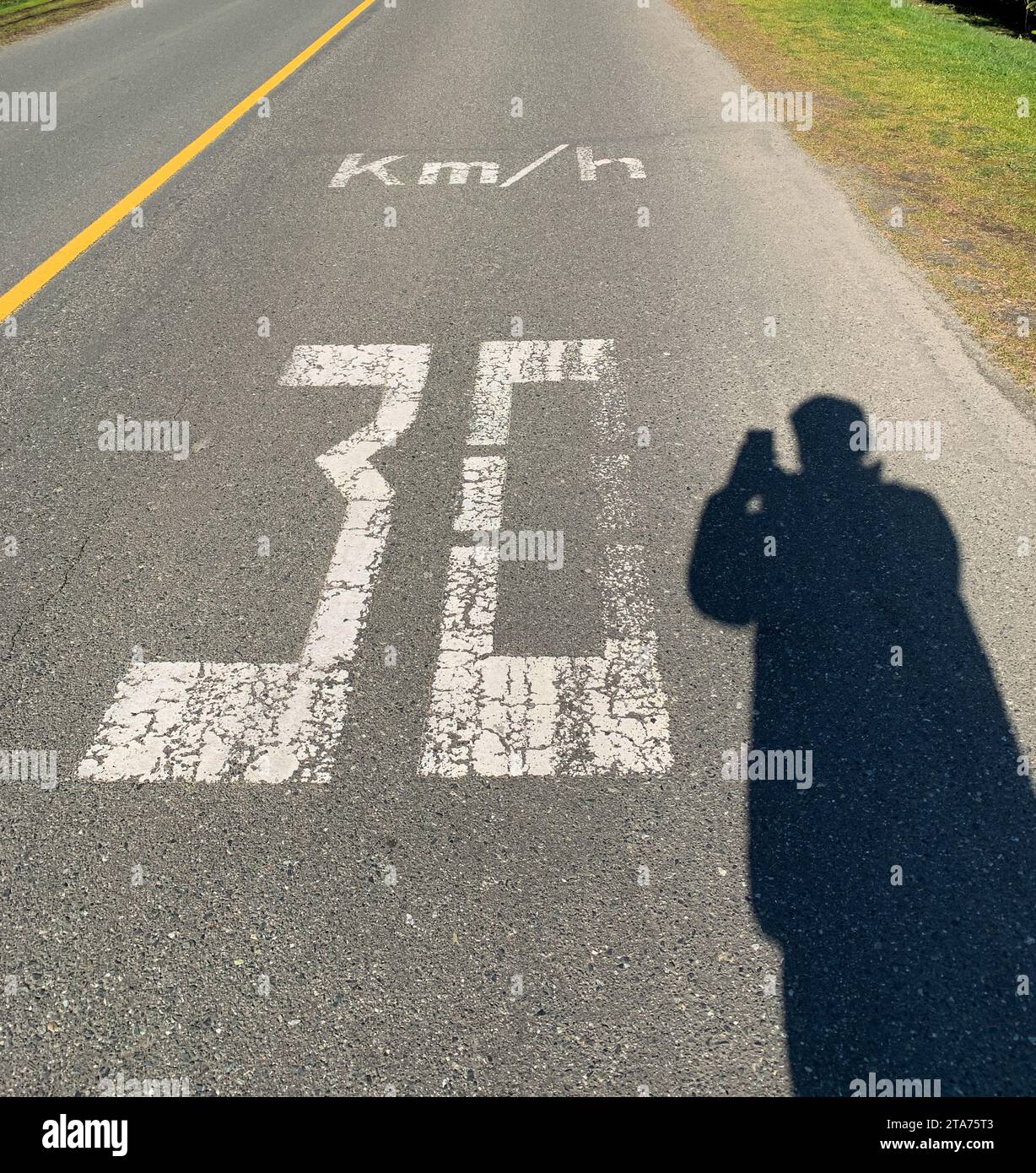 Silhouette of a man standing in a road taking a photo of a 30 km/hr ...