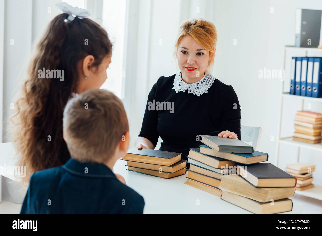 Teacher teaching children at school in lesson Stock Photo - Alamy