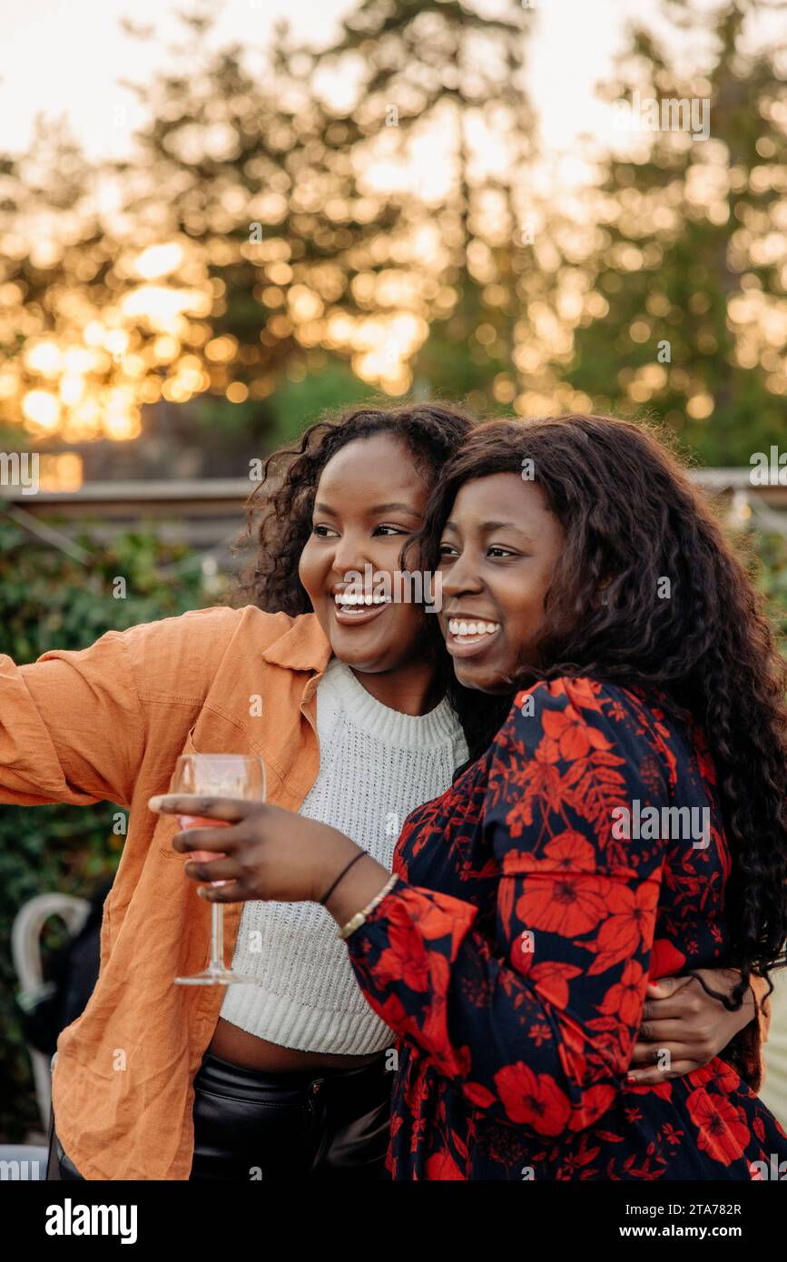 Happy young female friends enjoying a conversation on floor against ...