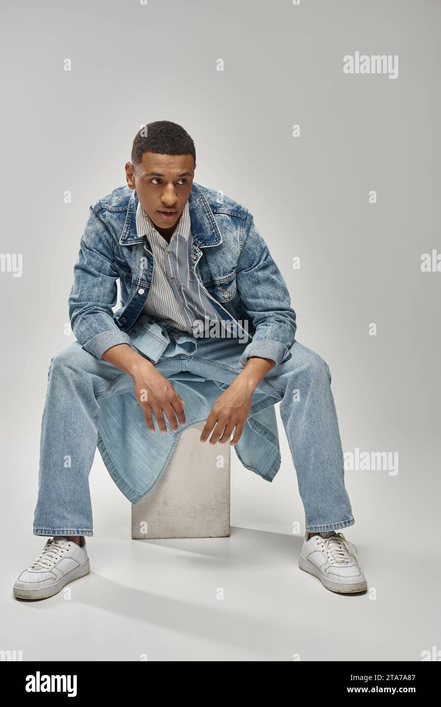 good looking african american male model in denim outfit sitting on ...