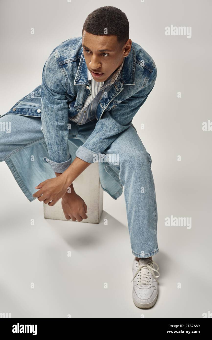 good looking african american male model in denim outfit sitting on ...