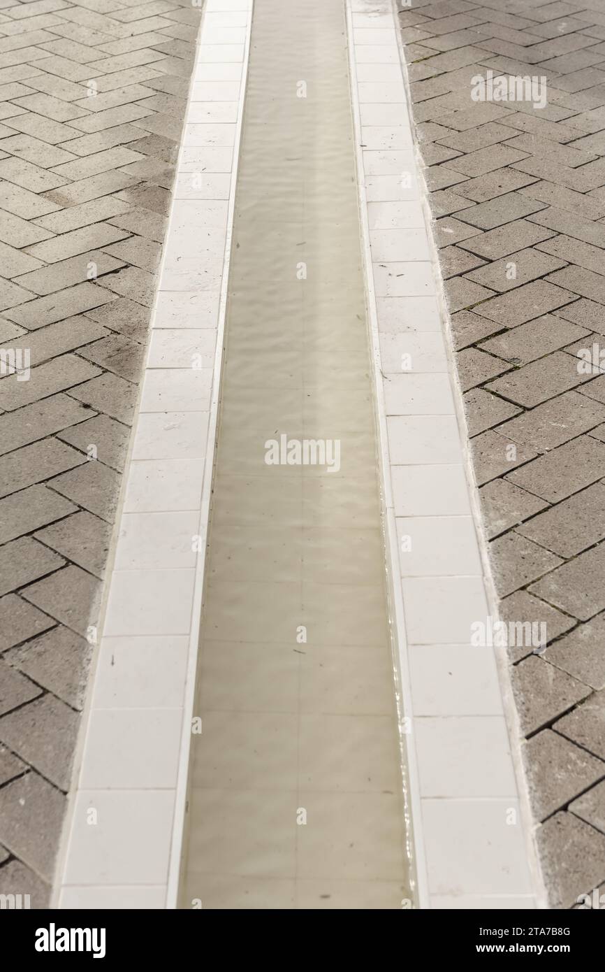 Canal filled with water with white square tiles in the center of the ...