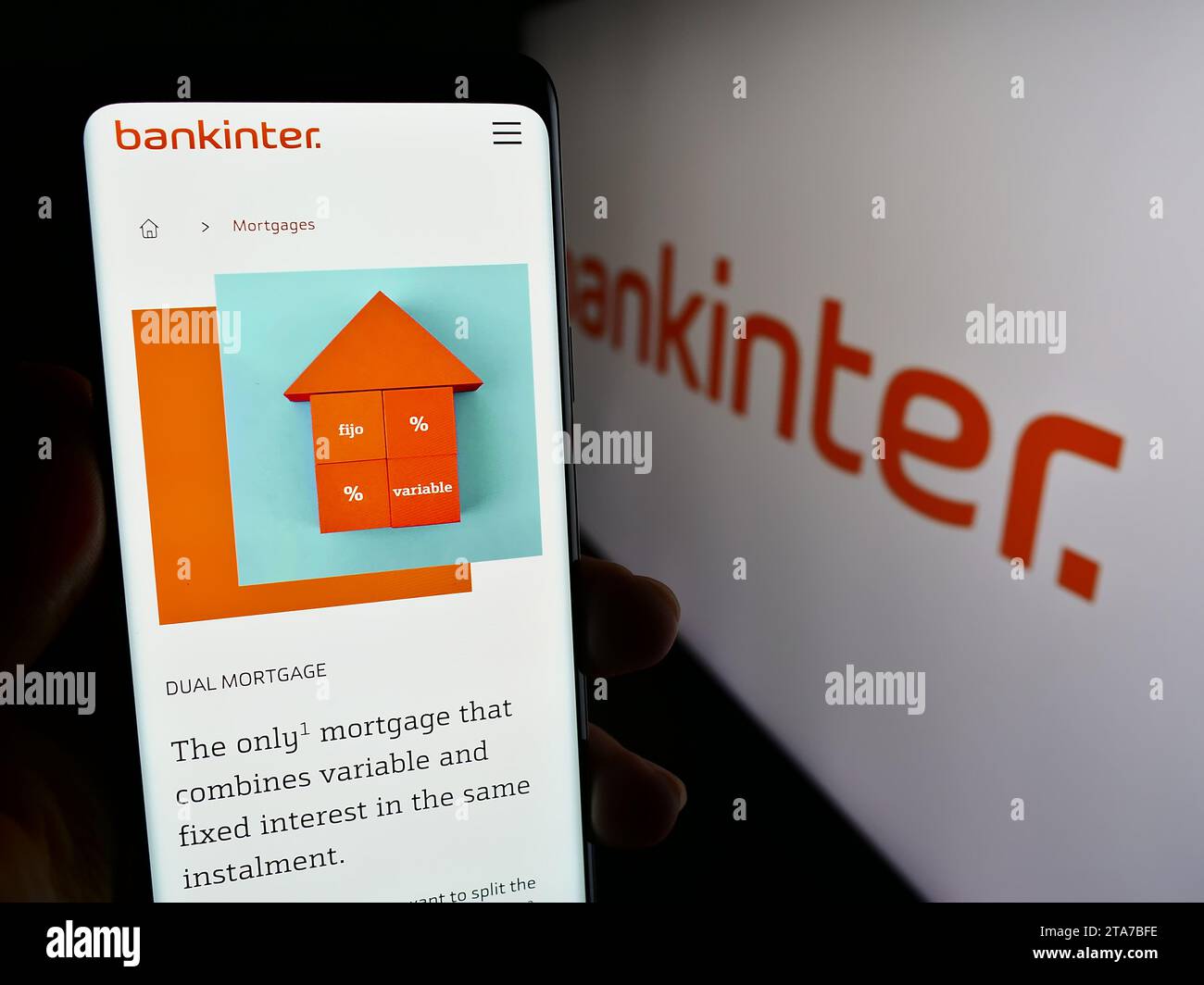 Person holding cellphone with webpage of Spanish financial services company Bankinter S.A. in ...