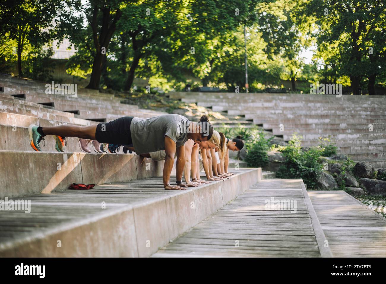 Team of multiracial male and female friends doing push-ups on steps Stock Photo - Alamy