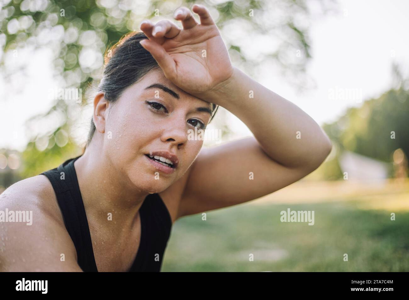 Portrait of perspiring woman with head in hand at park Stock Photo - Alamy