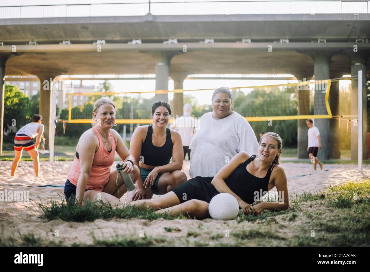 Portrait of multiracial female friends at volleyball ground Stock Photo ...