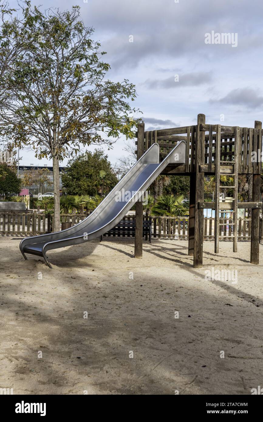 A metal slide with an unvarnished wooden structure Stock Photo - Alamy